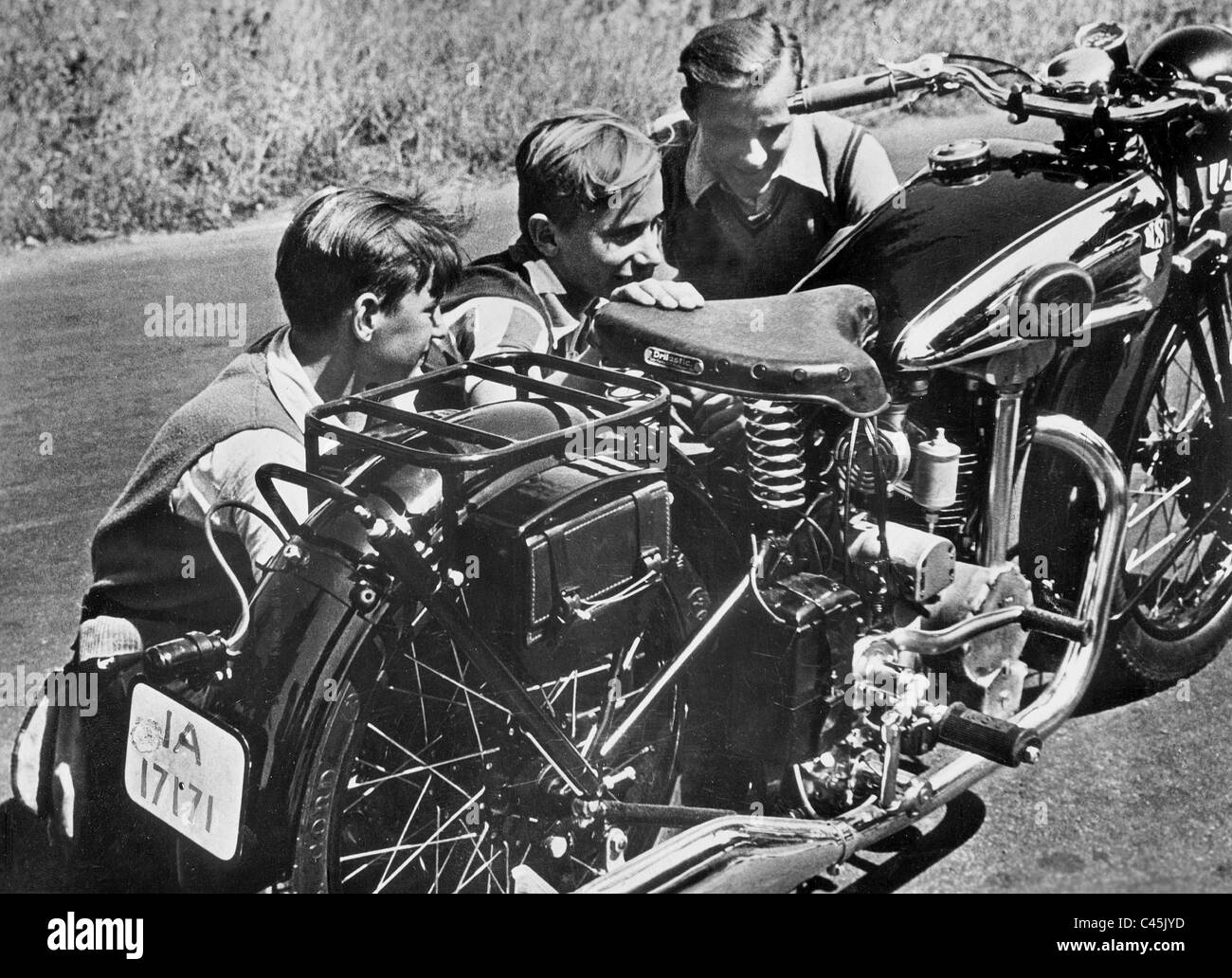 Young men look at a motorcycle Stock Photo - Alamy