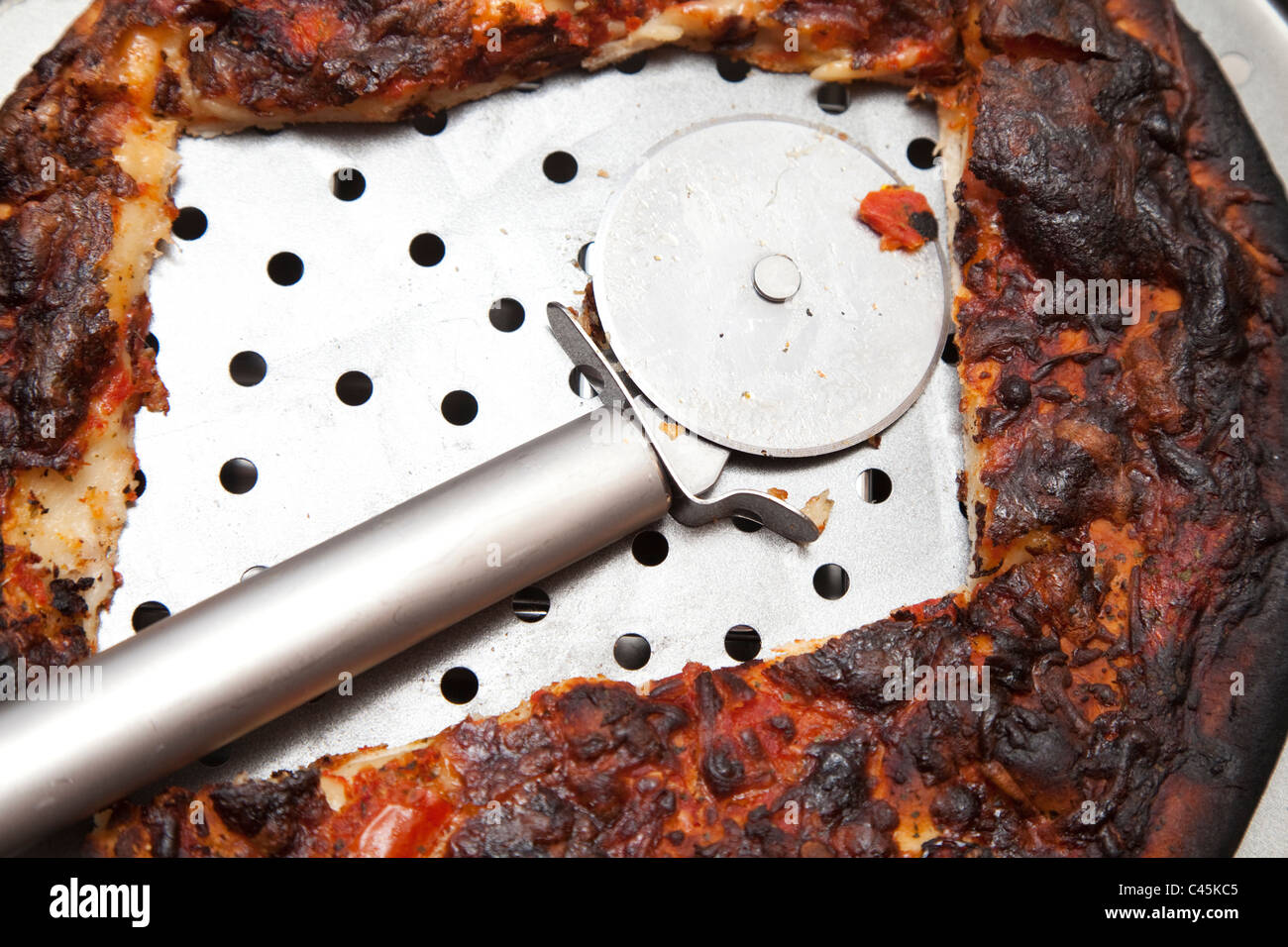 A burnt pizza with a circular pizza slicer England UK Stock Photo - Alamy