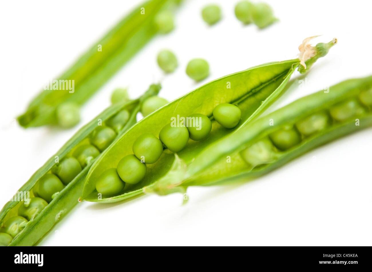 Green peas pods over a white background Stock Photo - Alamy