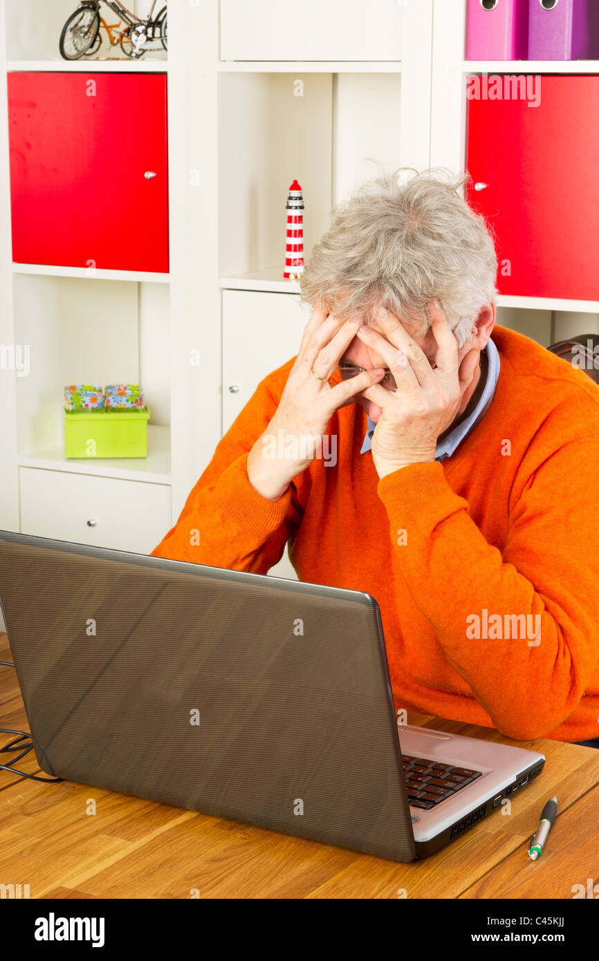 Elderly man is working at home with laptop Stock Photo - Alamy