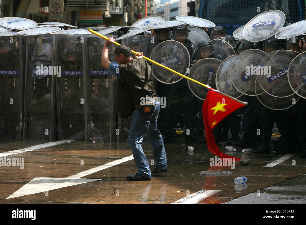 Man with chinese flag against police barrier, Macau Stock Photo - Alamy