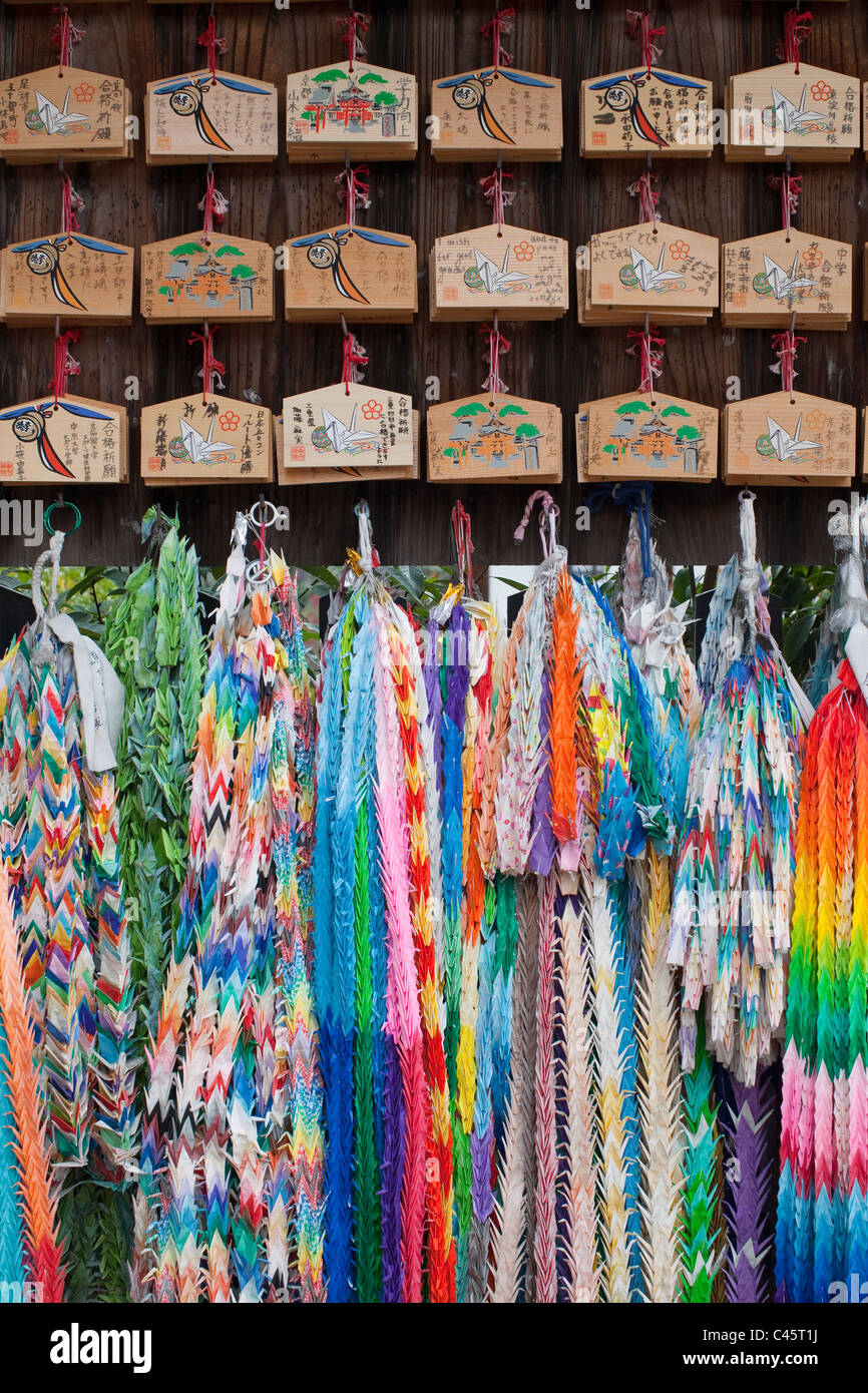 Origami folded paper cranes and wooden plaques with wishes and prayers ...
