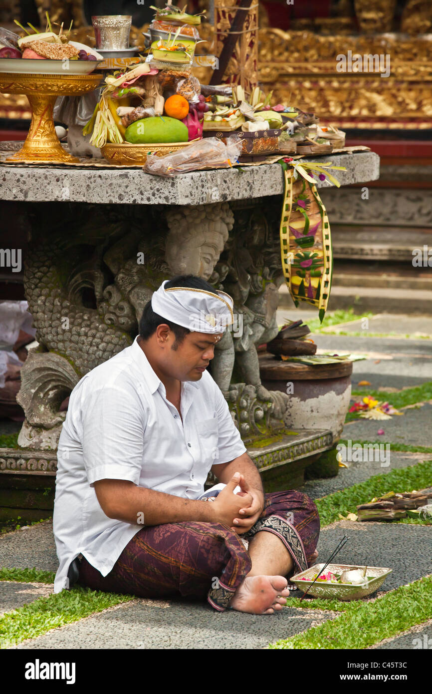 A Hindu man prays at PURA TAMAN SARASWATI during the GALUNGAN FESTIVAL ...