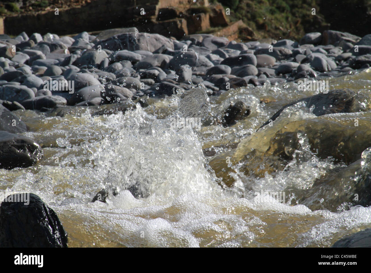 A stream rushing over the beach at Millook, Cornwall, UK Stock Photo ...
