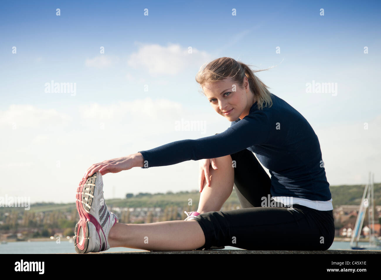 woman stretching leg muscles pre and post workout Stock Photo - Alamy