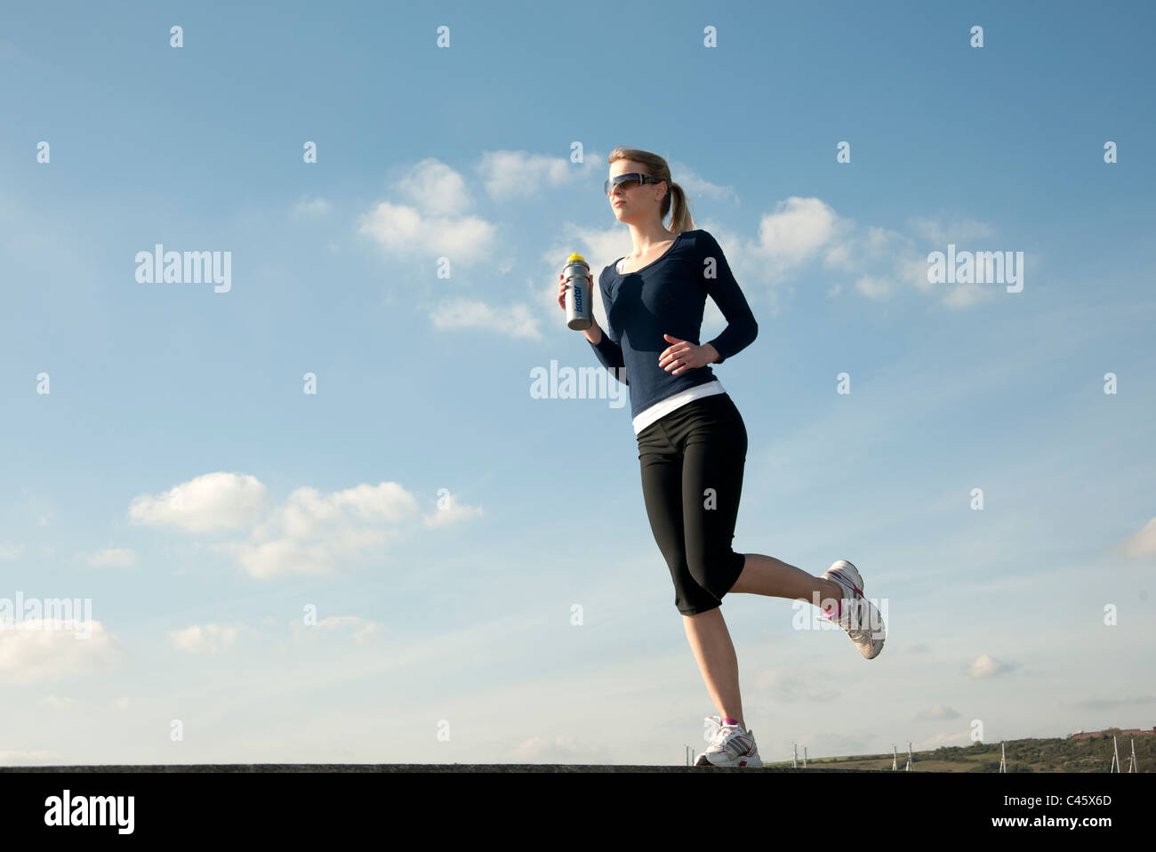 woman running on a sunny day blue sky Stock Photo - Alamy