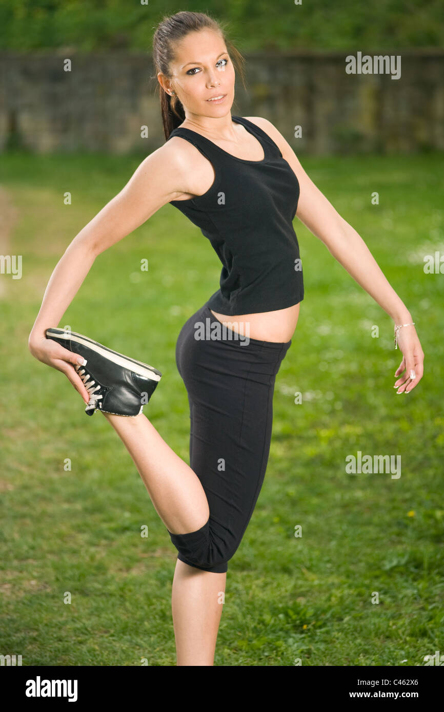 Gorgeous young slender fitness girl streching outdoors in nature Stock ...