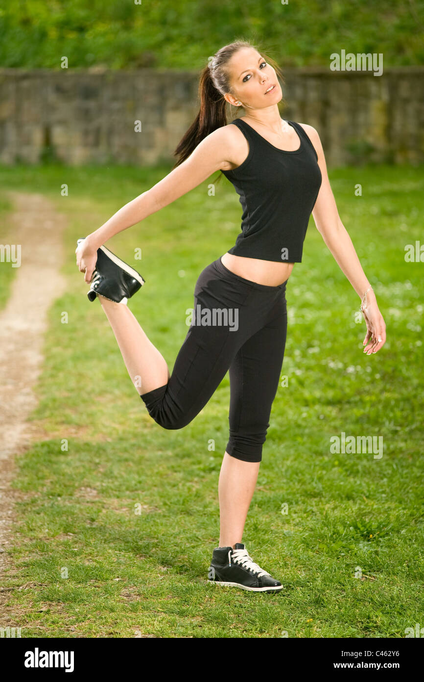 Gorgeous young slender fitness girl streching outdoors in nature Stock ...