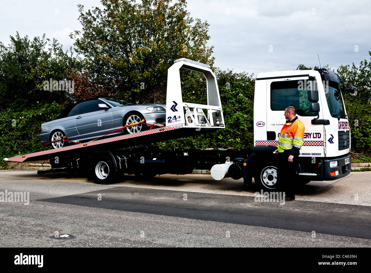 Recovery truck picking up car from the side of the road Stock Photo - Alamy