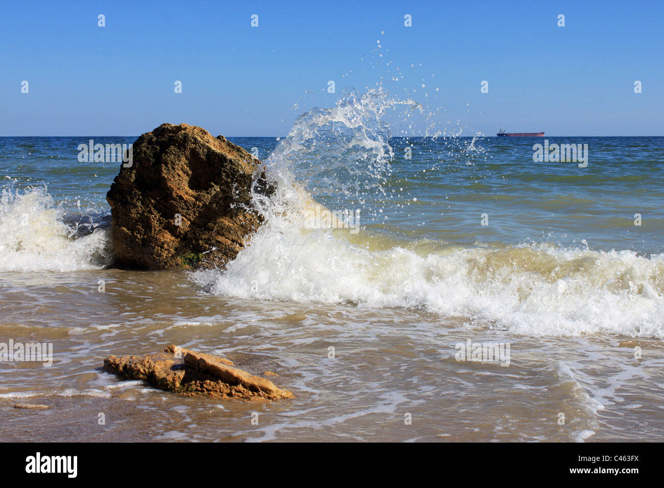 seaside at summer day: splashes of wave over rock Stock Photo - Alamy