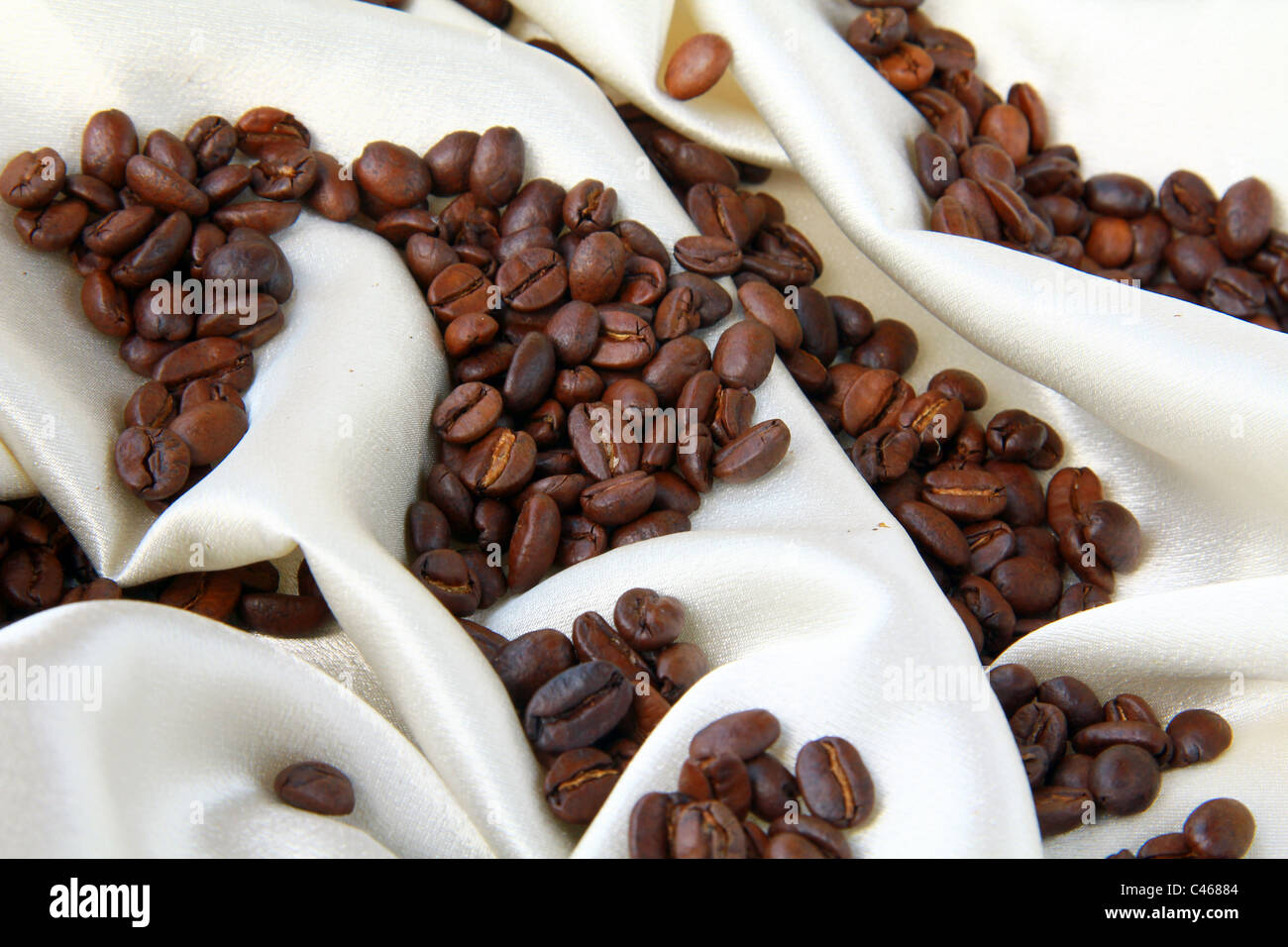 coffee beans on a beige silk concept luxurious coffee Stock Photo - Alamy
