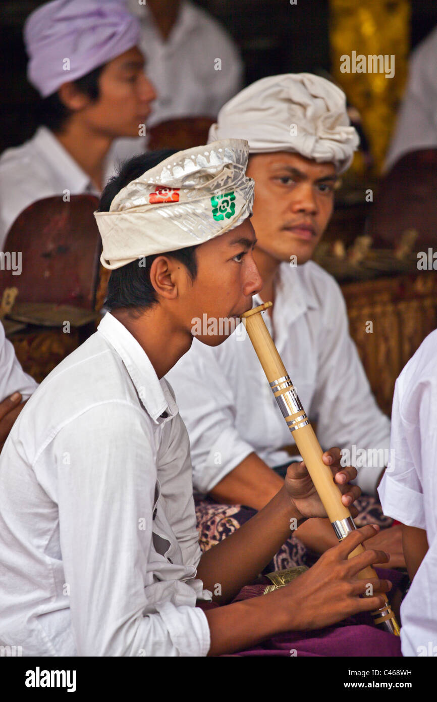 A BALINESE musician plays flute at PURA BEJI TEMPLE in the village of ...