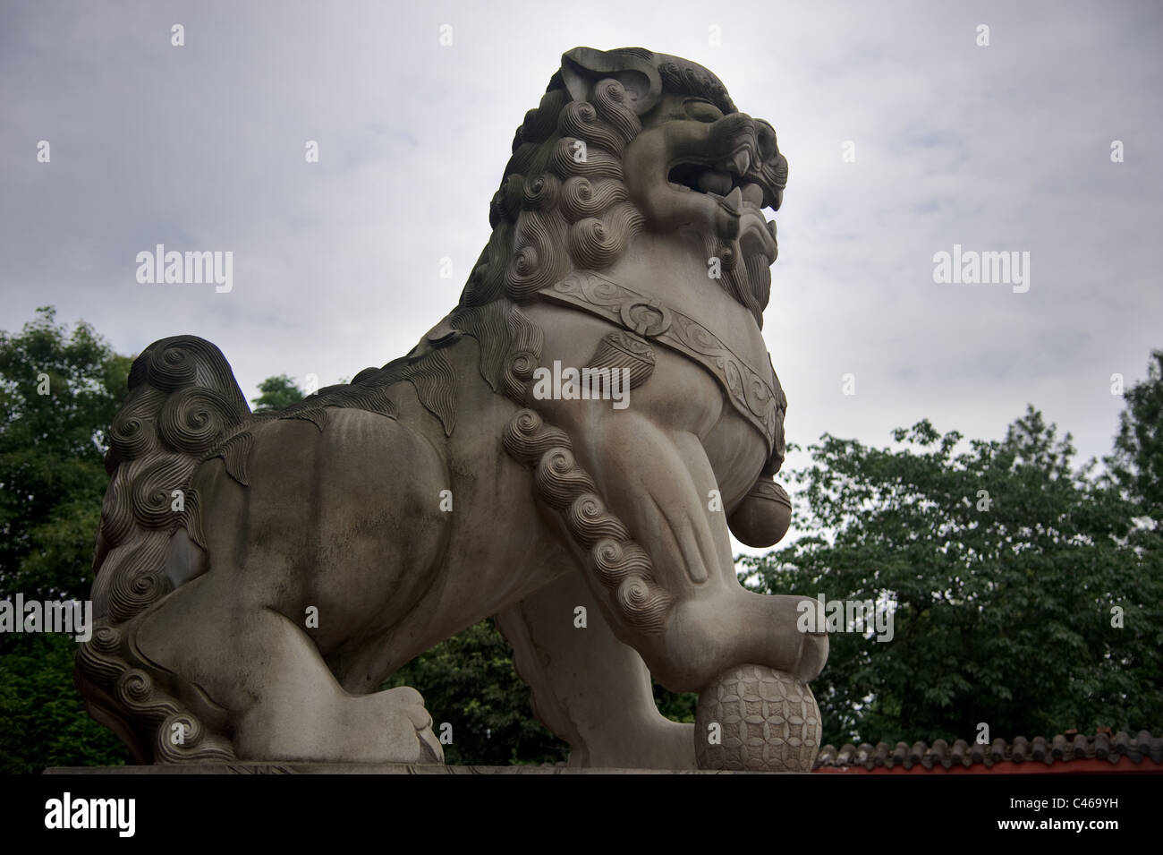 Male lion guard holding a ball in China Stock Photo - Alamy