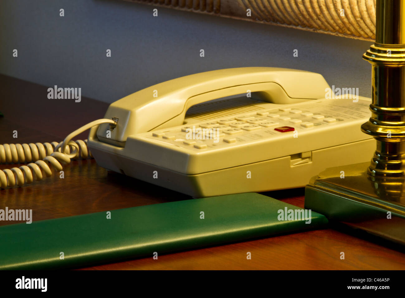 Business traveler's hotel room desk, familiar with its phone, lamp, and ...
