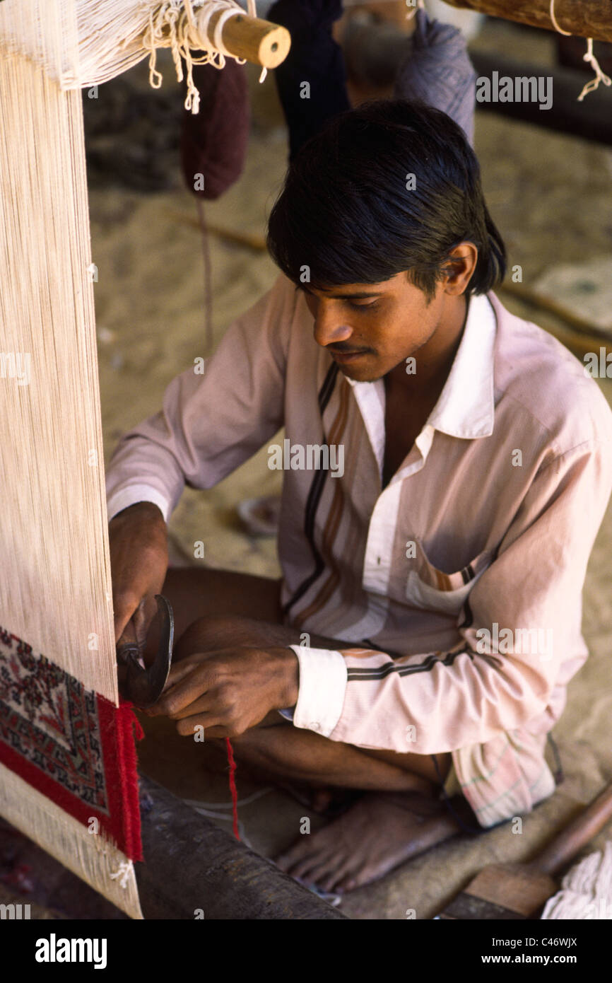 Man weaving rug on a loom in rug factory in Jaipur, Rajasthan, India ...