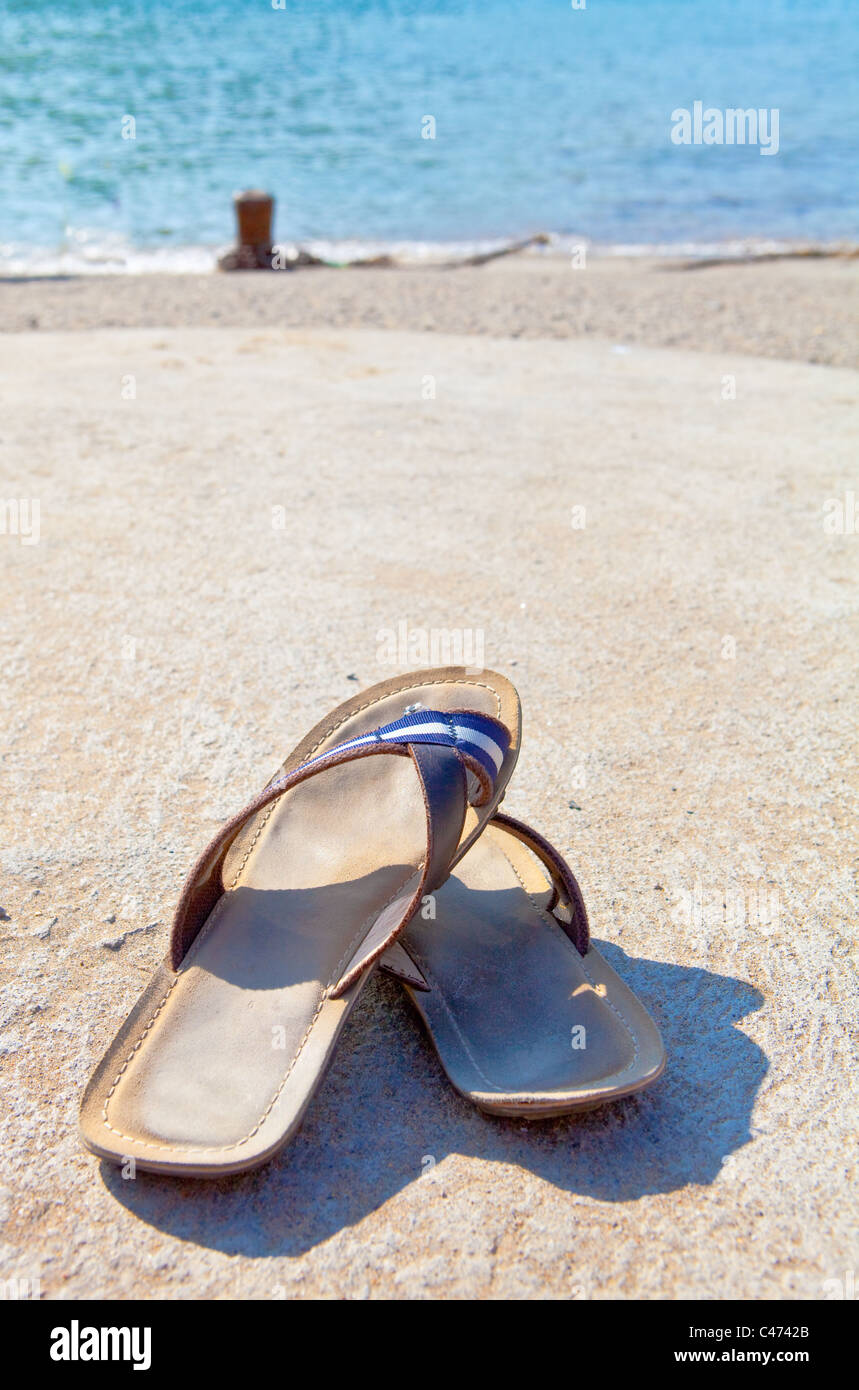 Summer holiday conceptual image of a pair of sandals by the sea Stock ...