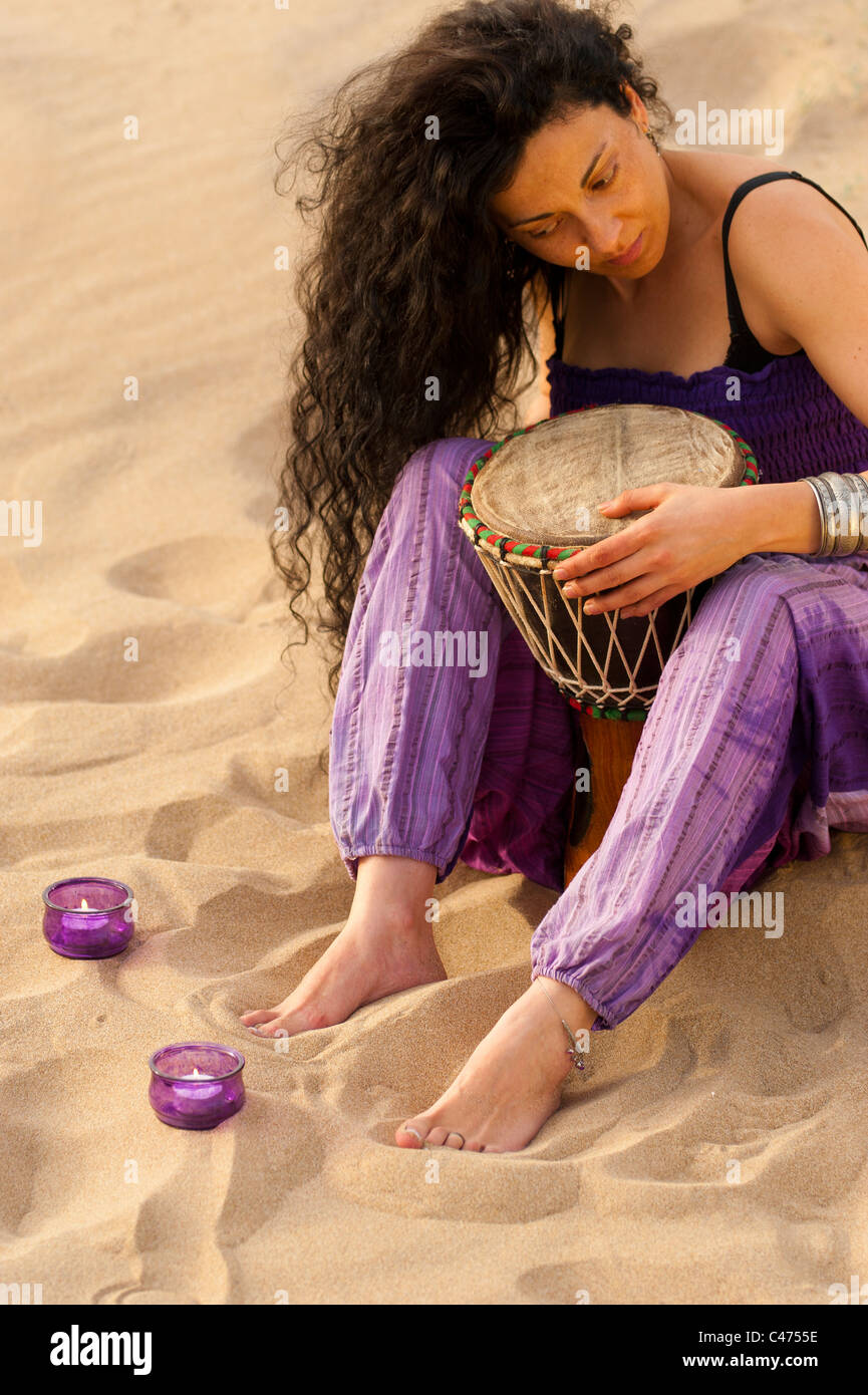 Woman outdoors enjoying the sunshine and playing her djembe Stock Photo ...