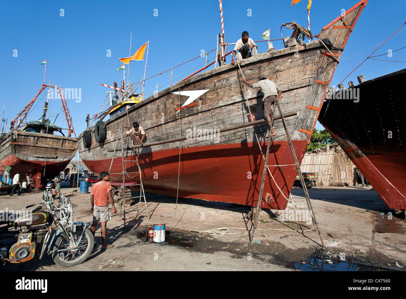 Men painting a fishing boat. Vanakbara shipyard. Diu. India Stock Photo ...