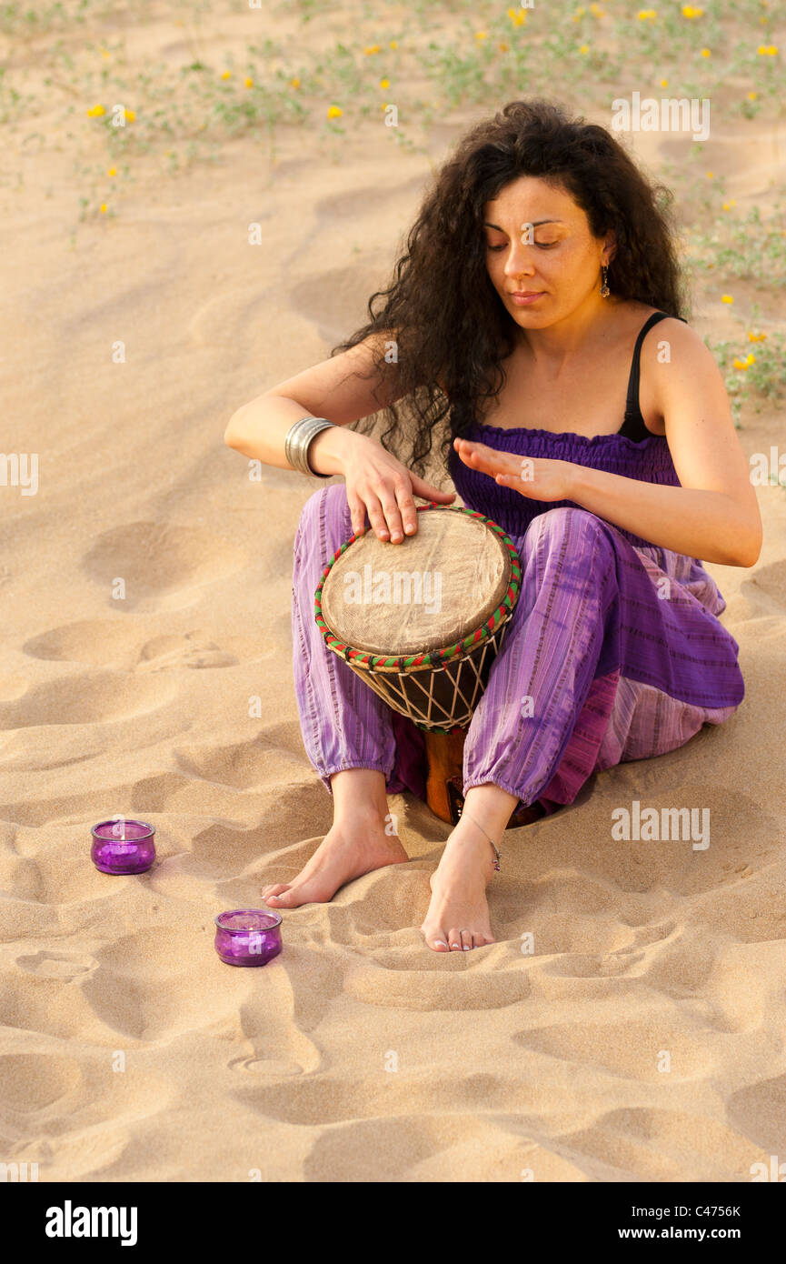 Woman outdoors enjoying the sunshine and playing her djembe Stock Photo ...