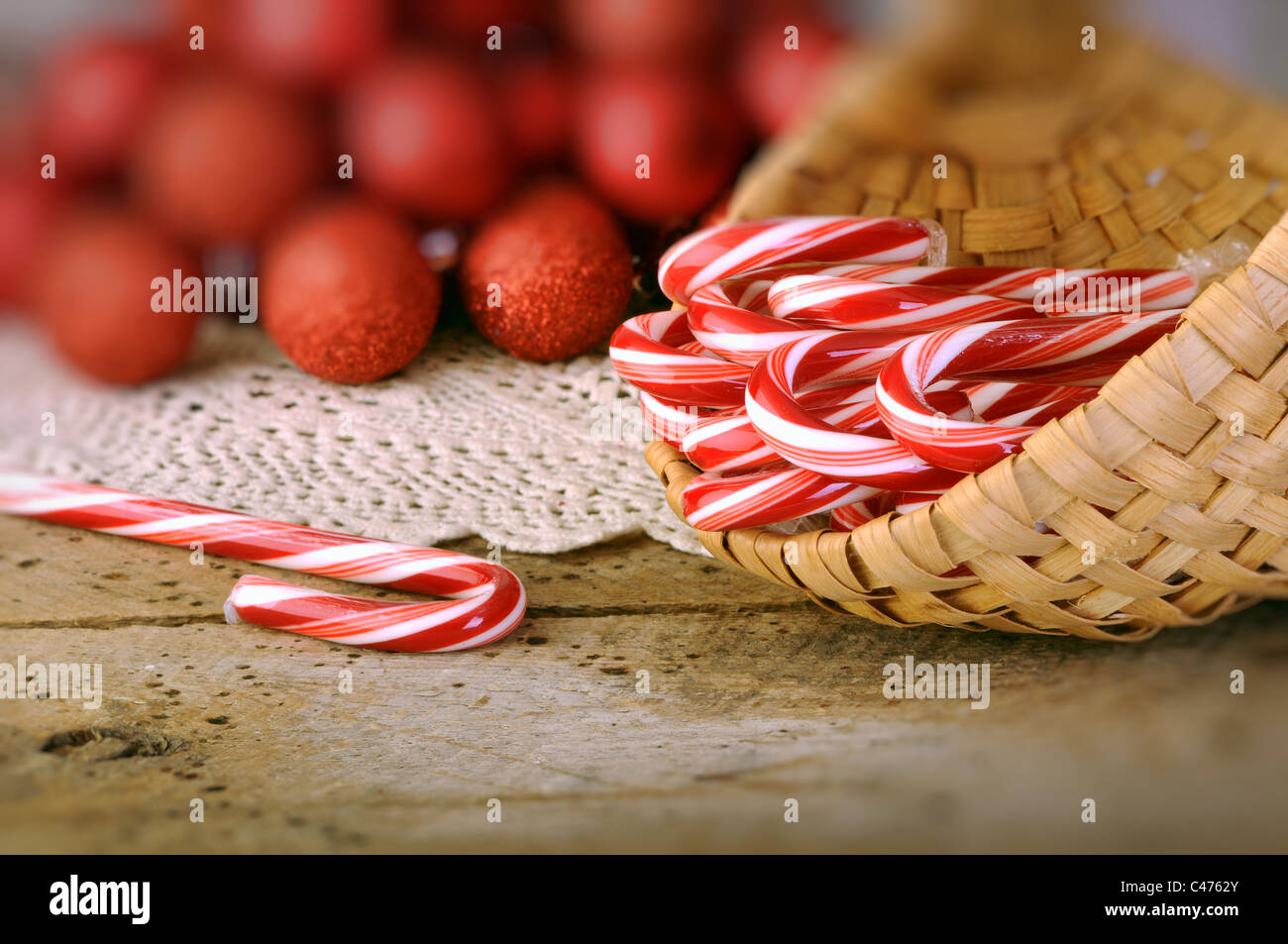 Candy canes in basket with Christmas balls in background on old vintage ...