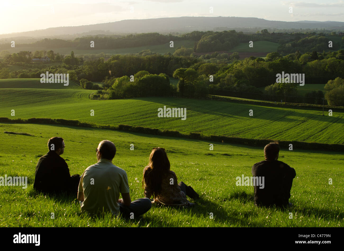 Four friends watching the sunset together in Worcestershire Stock Photo ...