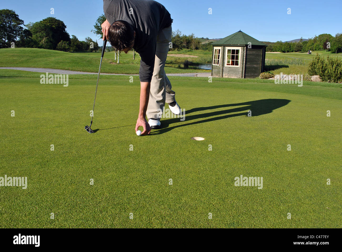 man placing the ball before putting Stock Photo - Alamy