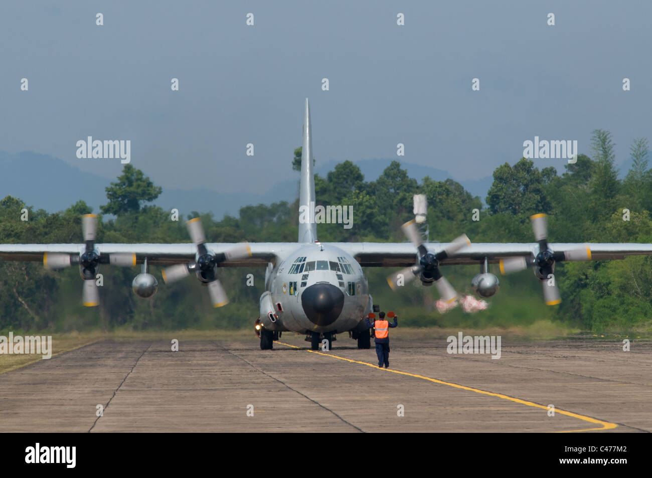 Military transport aircraft at airport in tropical condiditions ...