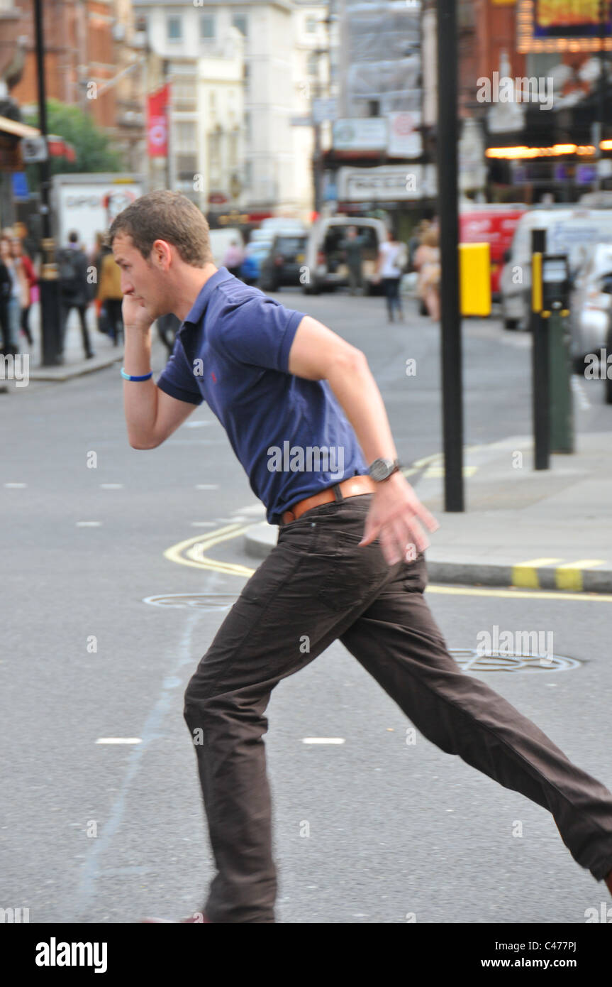 Man running across busy road talking on mobile phone Stock Photo - Alamy