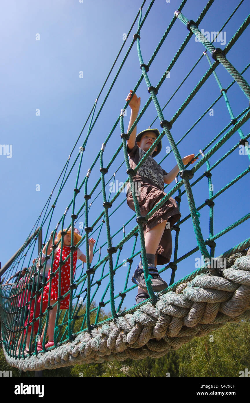Children walking across a rope bridge. View from below Stock Photo - Alamy