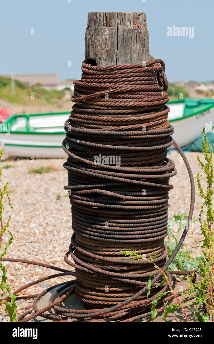 Steel cable wrapped around wooden post on beach UK boats Stock Photo ...