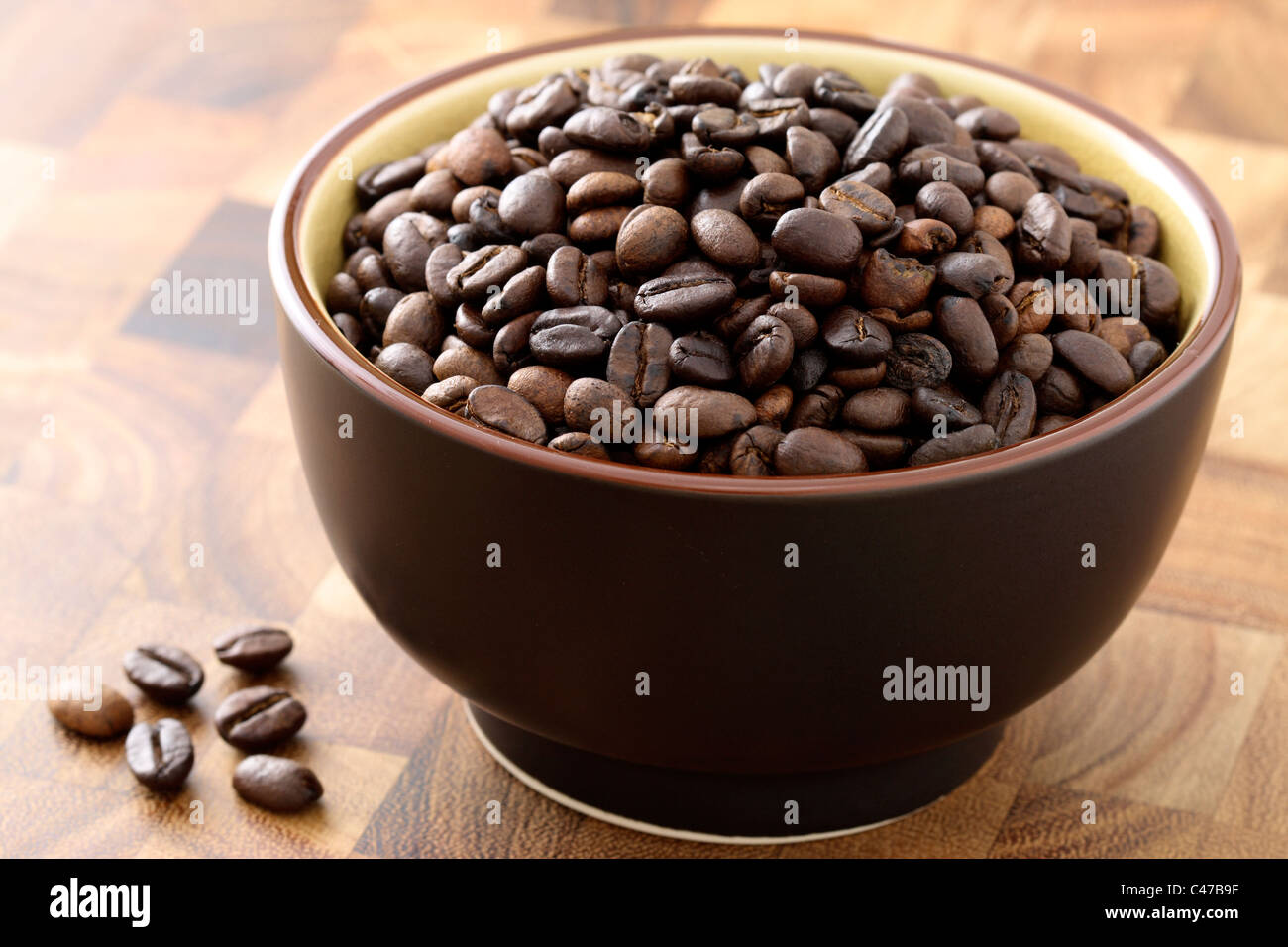 cup overflowing with dark roasted coffee beans, fresh and ready to ...