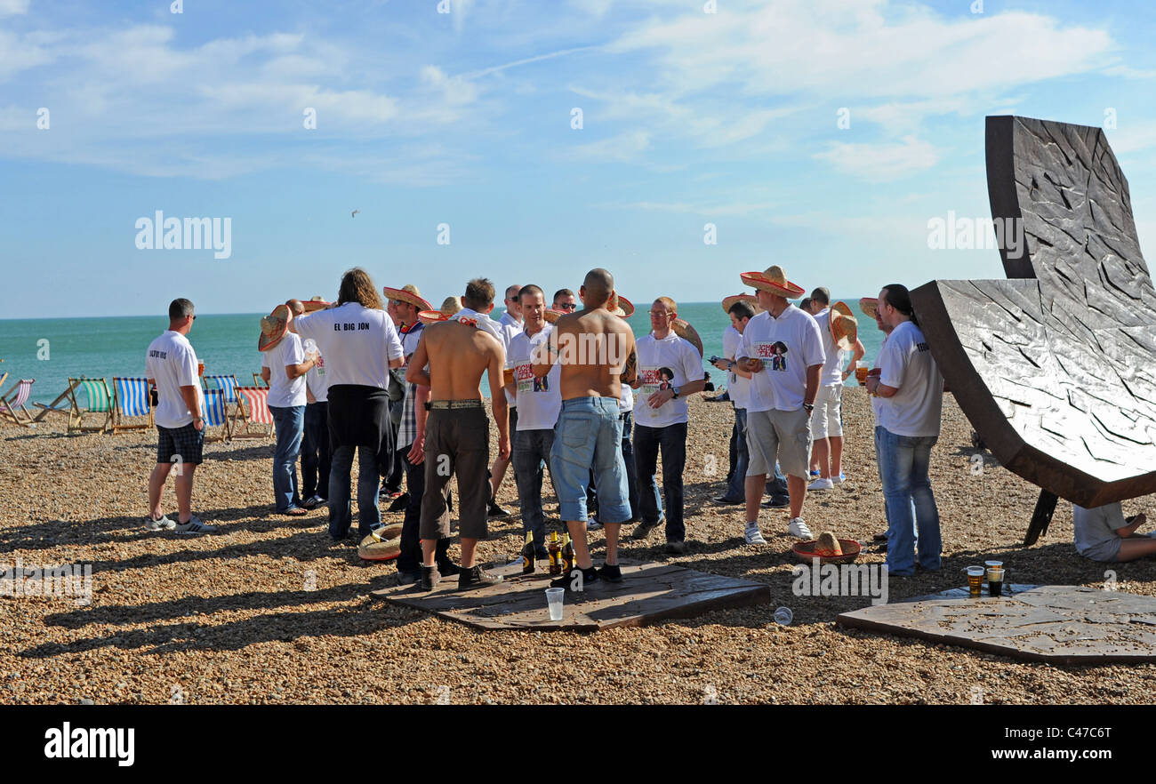 Mens stag party gather on Brighton seafront and beach to enjoy a drink ...
