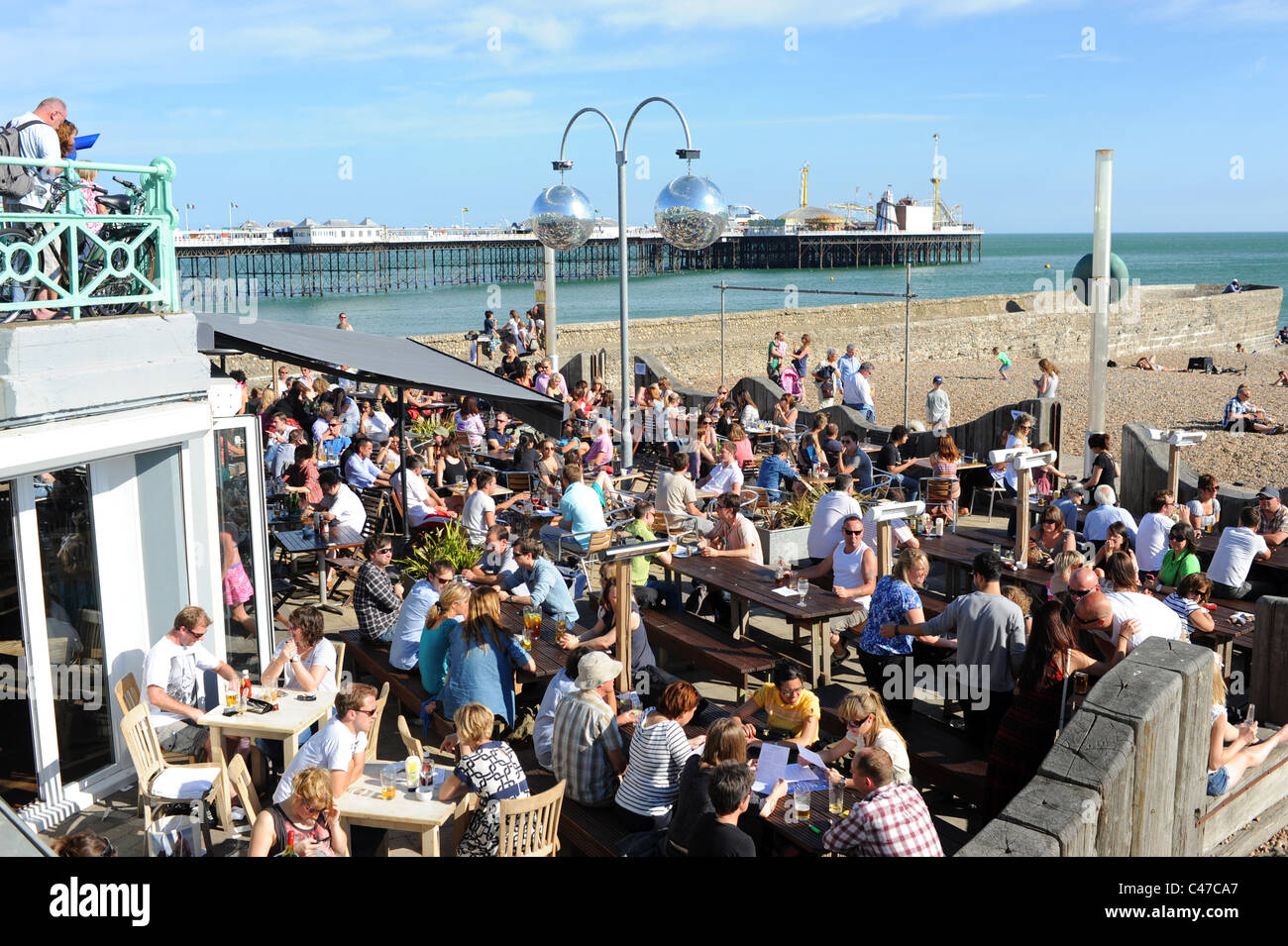 Silver metal balls reflecting sun and beach at Brighton crowded ...