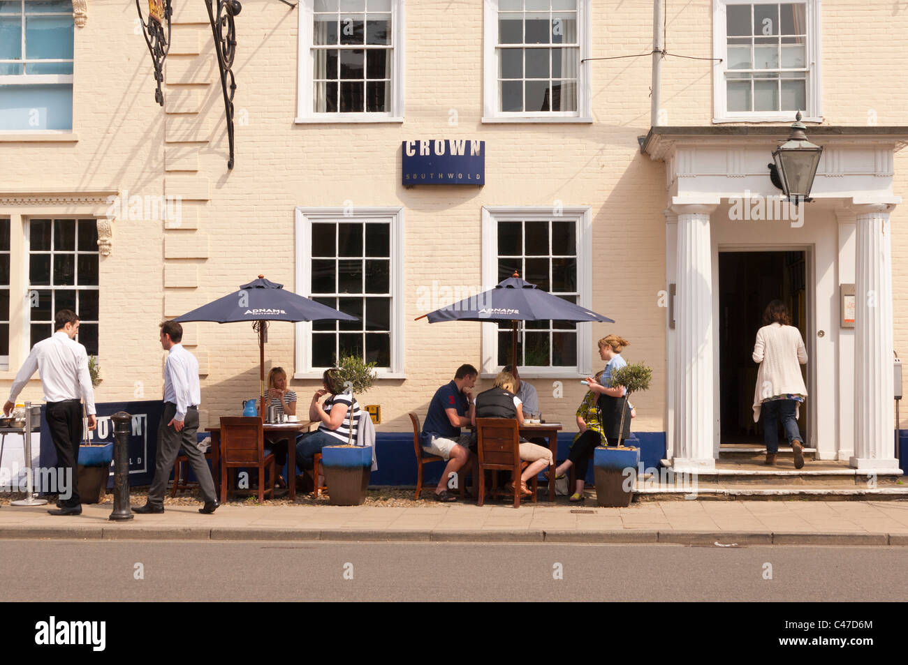 The Crown pub with people sitting outside in Southwold , Suffolk ...