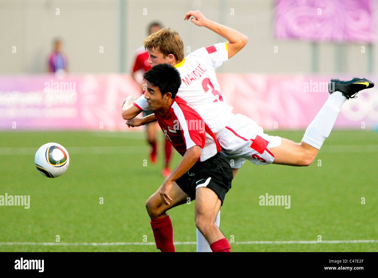 Singapore's Bryan Neubronner(left) uses his body to block the oncoming ...