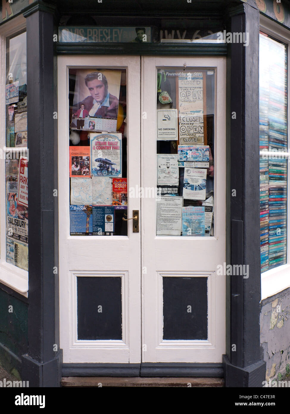 Corner shop door with faded posters and adverts Stock Photo - Alamy