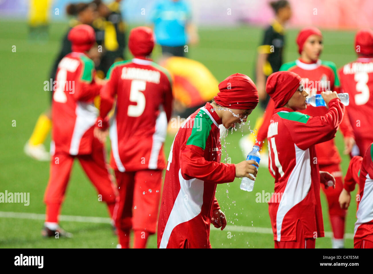 Iranian players receiving water from the sidelines during a break in ...