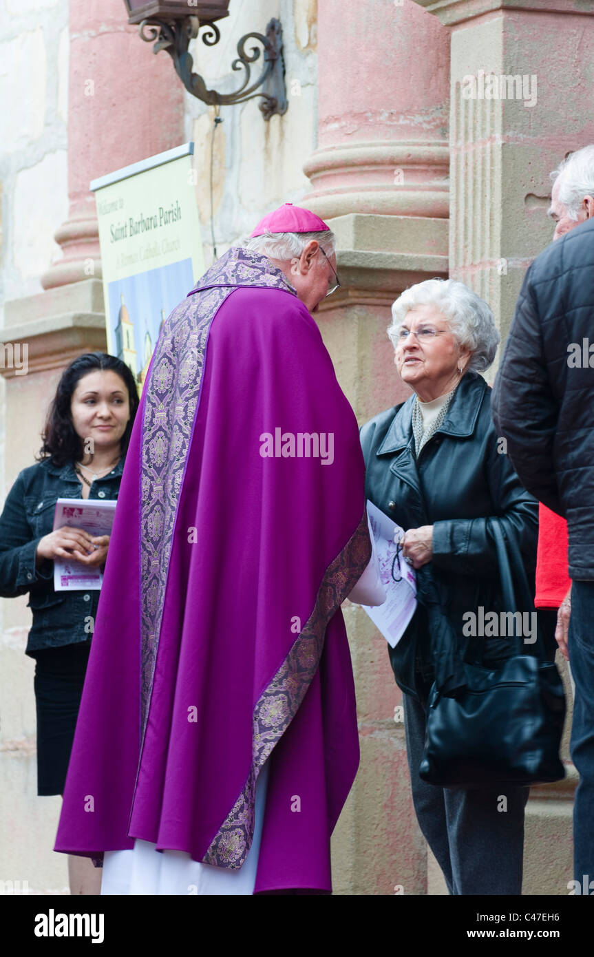 Catholic priest greeting the congregation at the end of a church mass ...