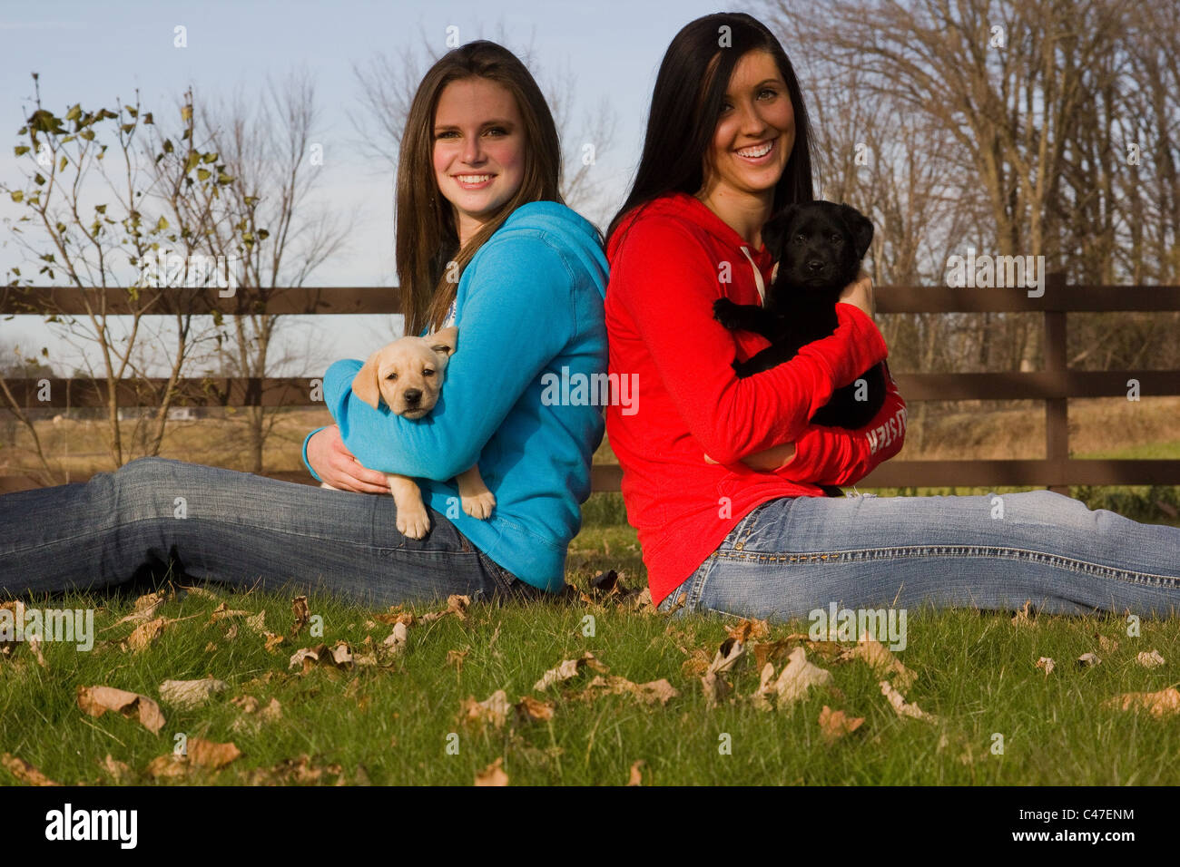 Two teen-aged girls hold Labrador retriever puppies Stock Photo - Alamy