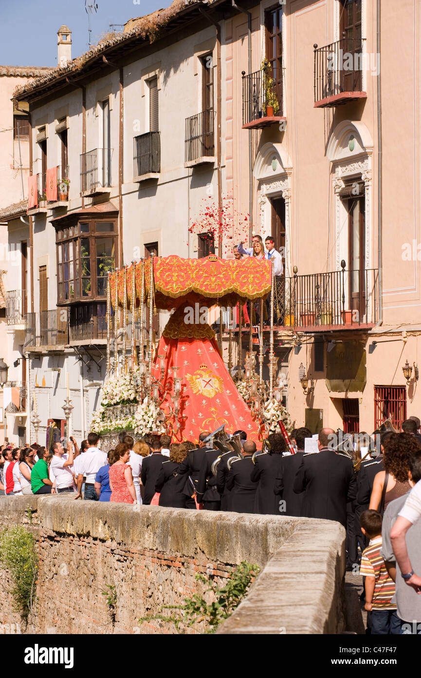 A traditional religious parade along a narrow street in Granada ...