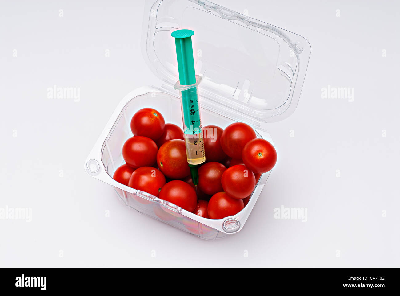 Cherry tomatoes in clear plastic box with syringe injection Stock Photo ...
