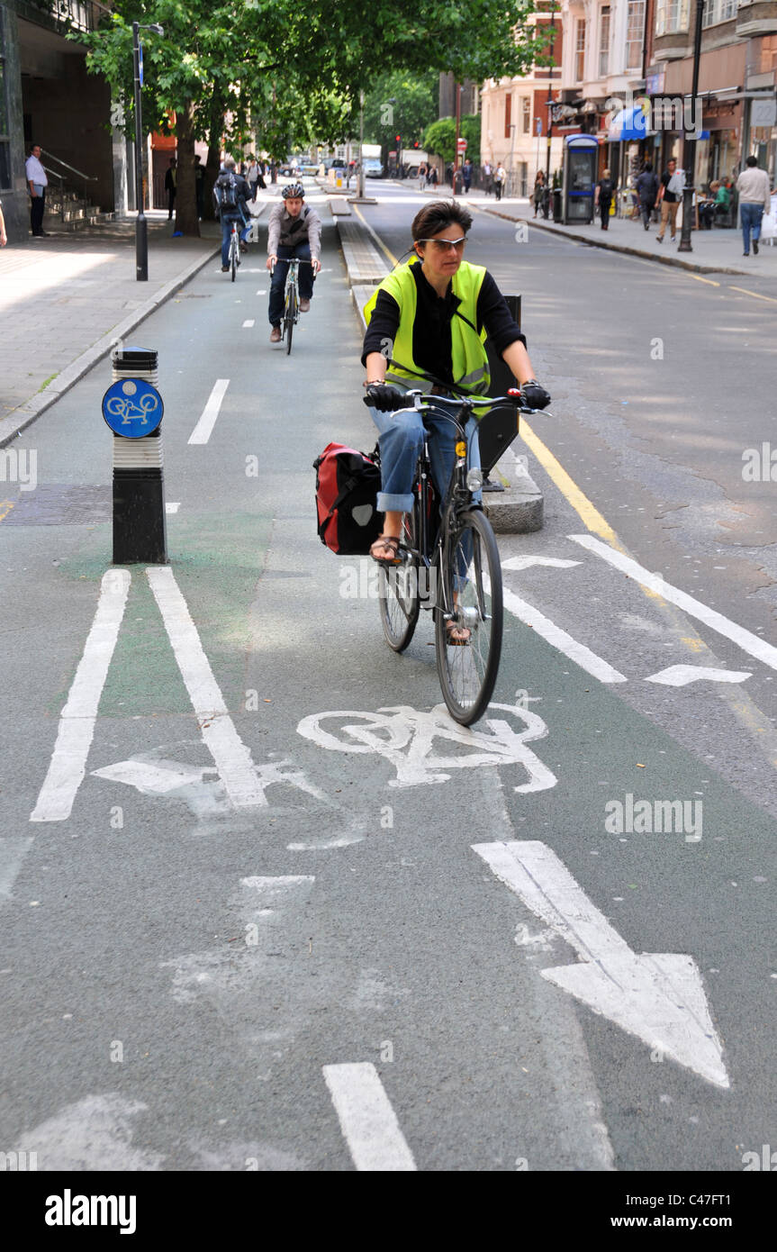 Cycle lane cyclist wearing yellow jacket Stock Photo - Alamy