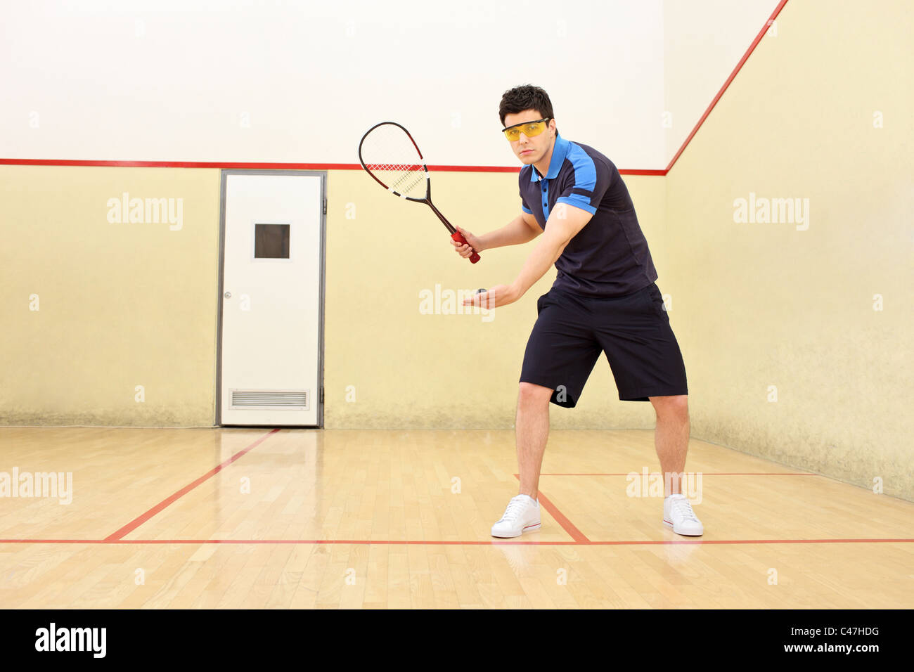 Squash player serving a ball in a squash court Stock Photo - Alamy