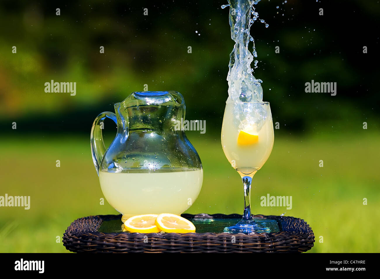 A lemon splashing into a glass of lemonade Stock Photo - Alamy