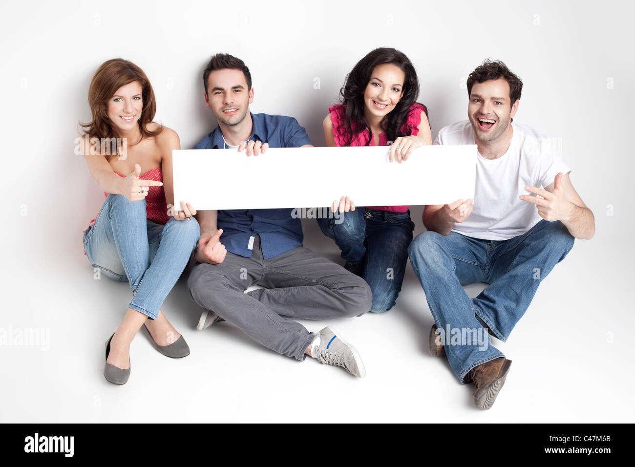 four friends showing a white board Stock Photo - Alamy