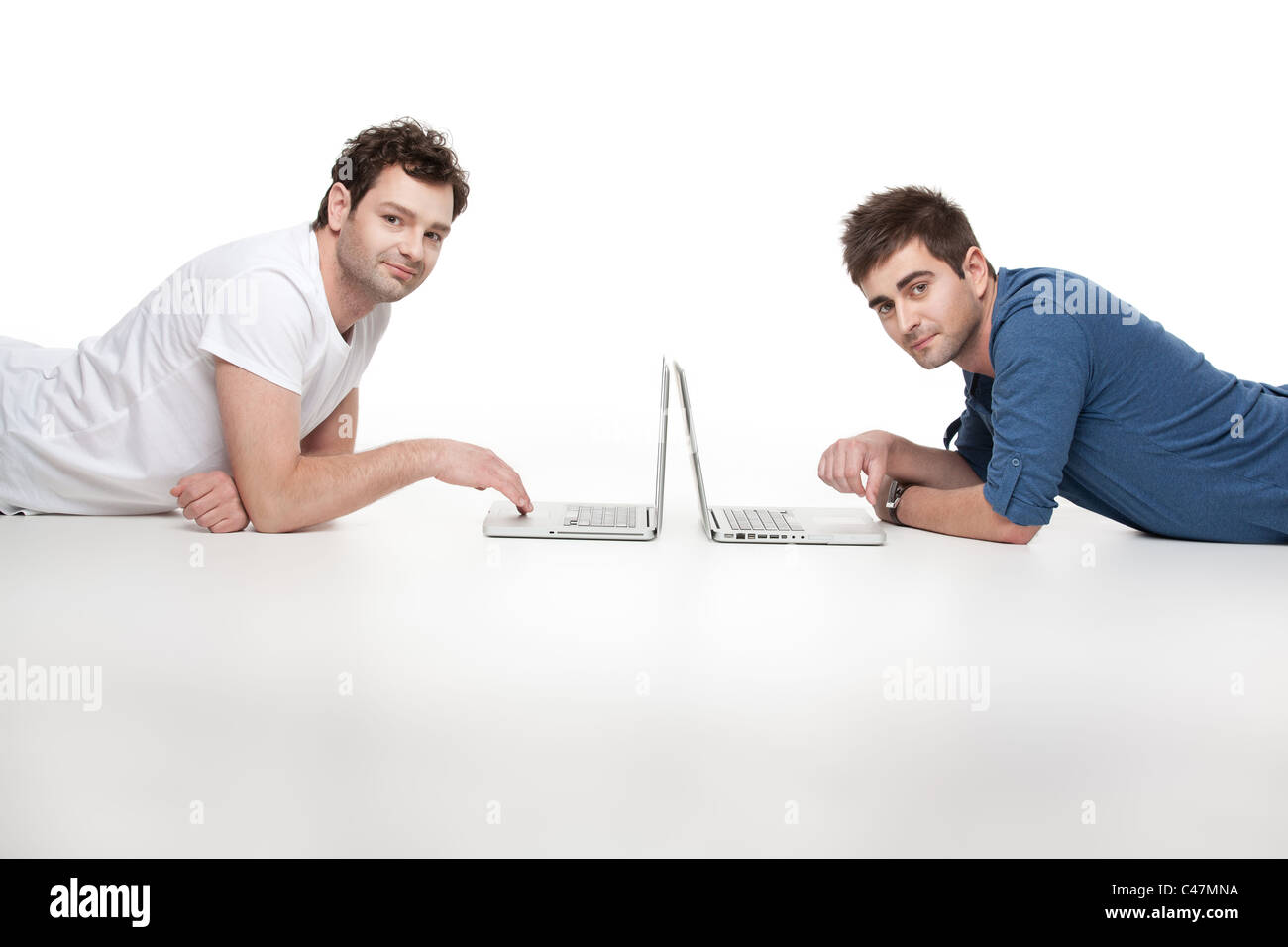 young men posing at camera in front of laptops Stock Photo - Alamy
