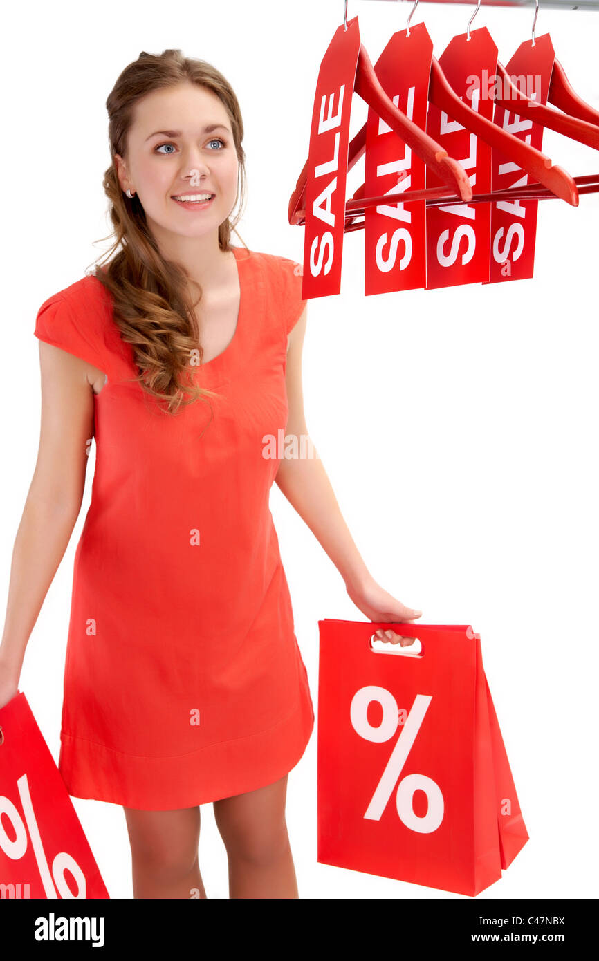Happy shopper carrying bags and looking at hangers with discount ...