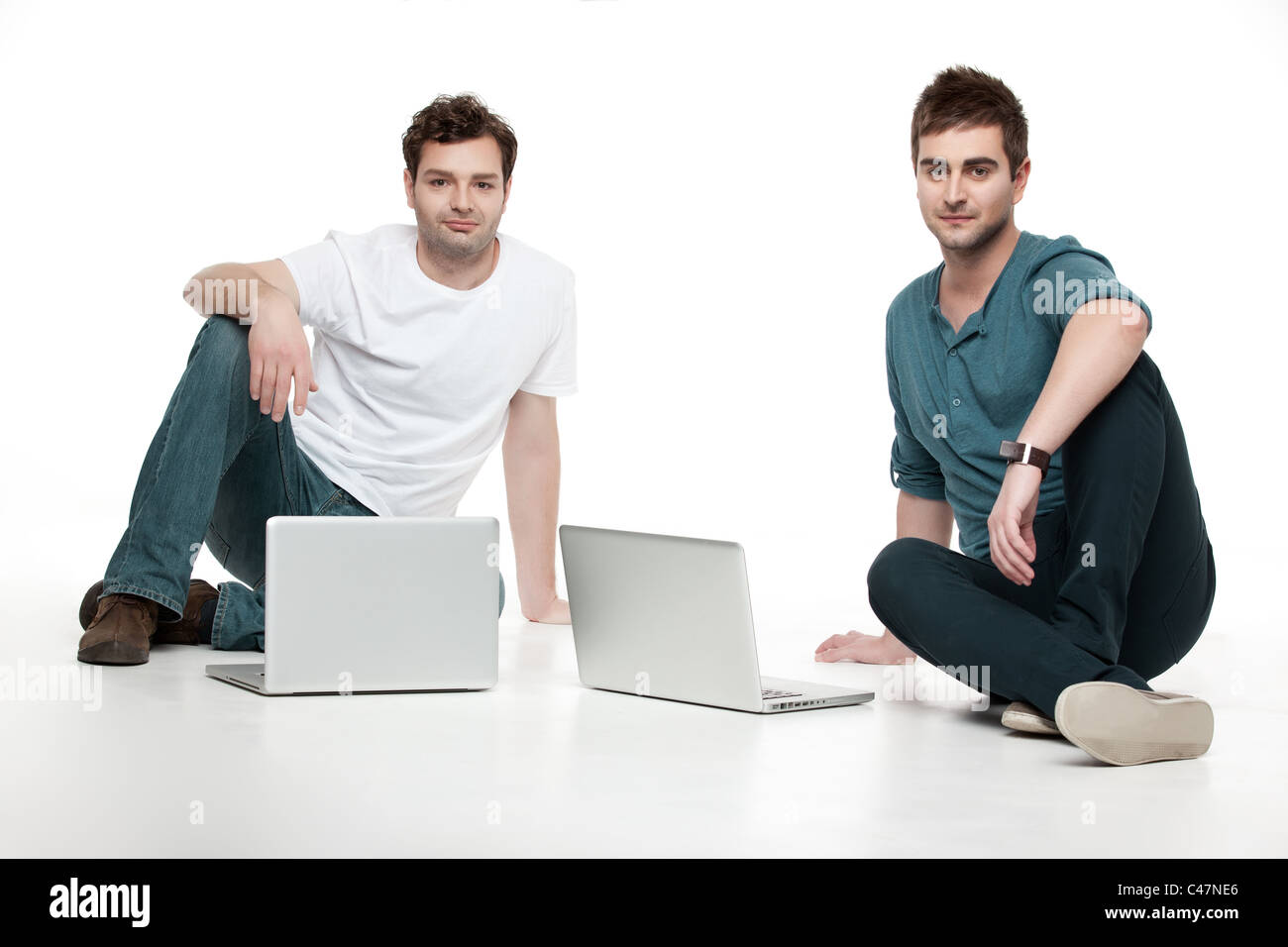two handsome men sitting with laptops Stock Photo - Alamy