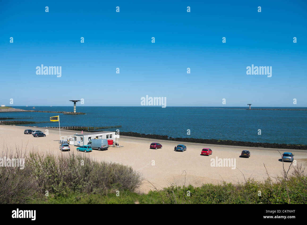 snack bar and parked cars on beach at the entrance of the port of ...