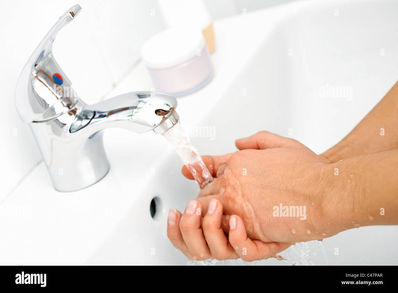 Close-up of human hands being washed under stream of pure water from ...